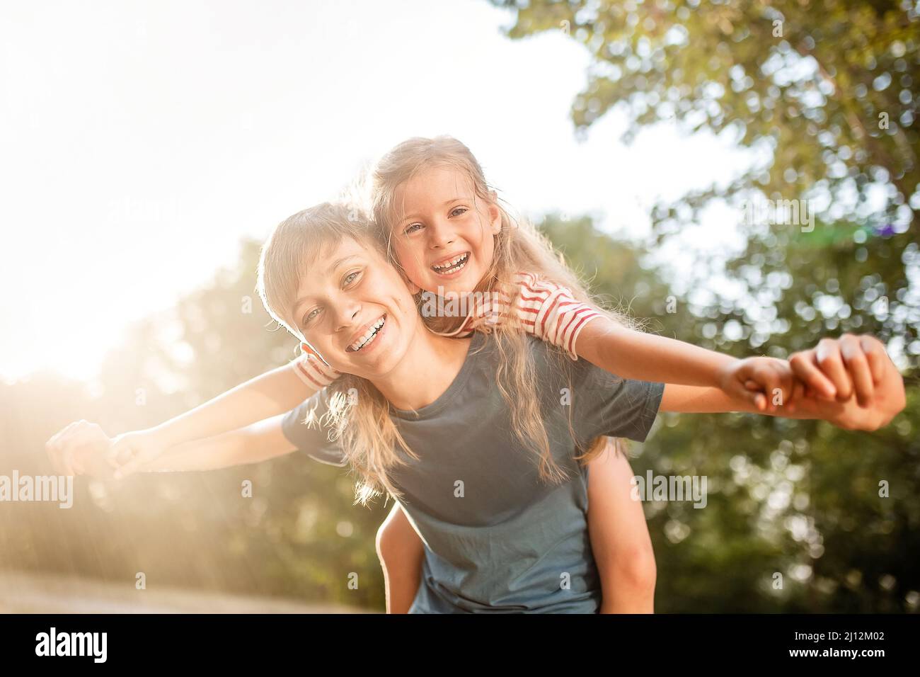 Happy children boy and girl frolic in the Park. The older brother plays ...