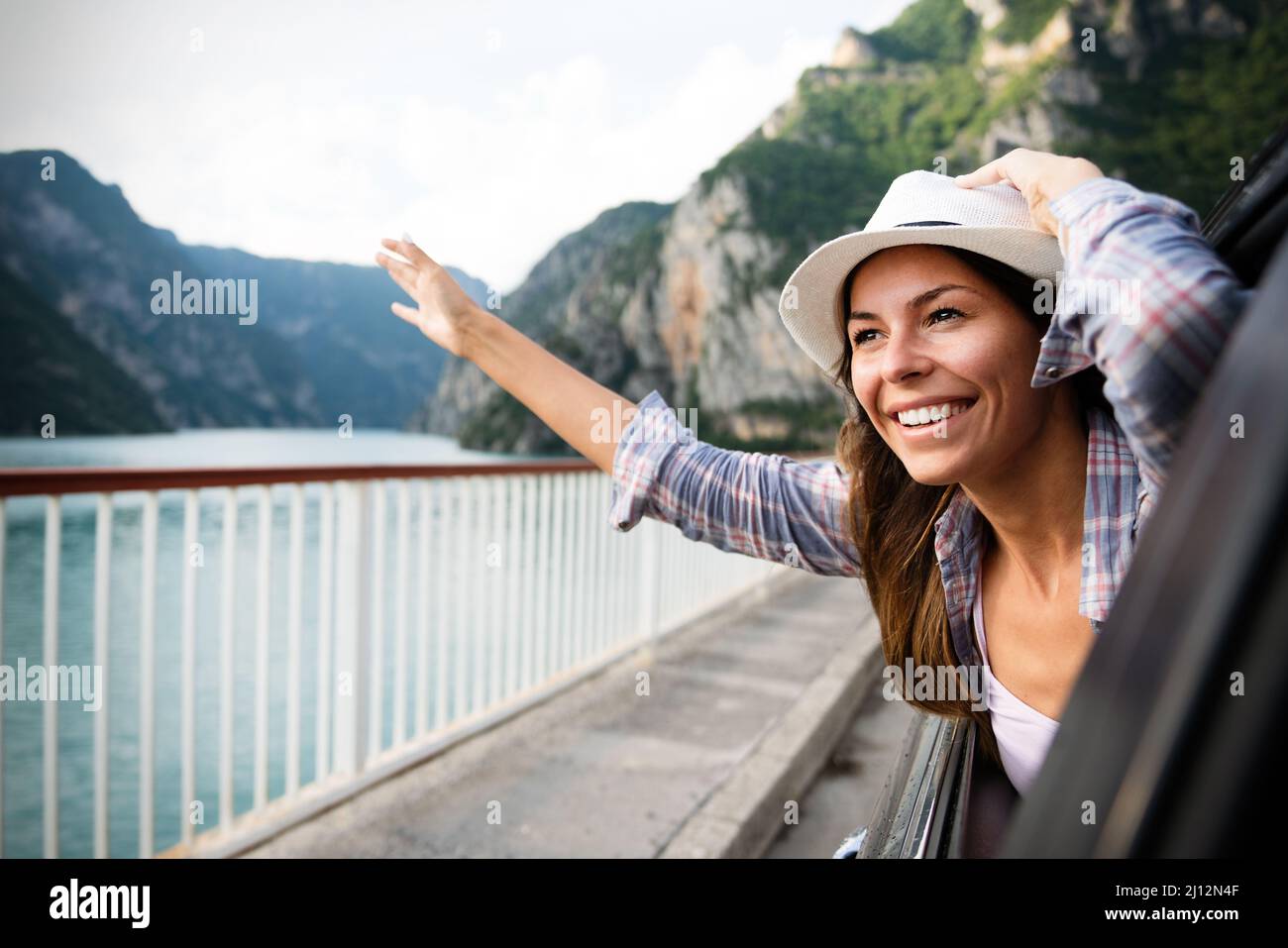Woman in car road trip waving out the window smiling Stock Photo - Alamy