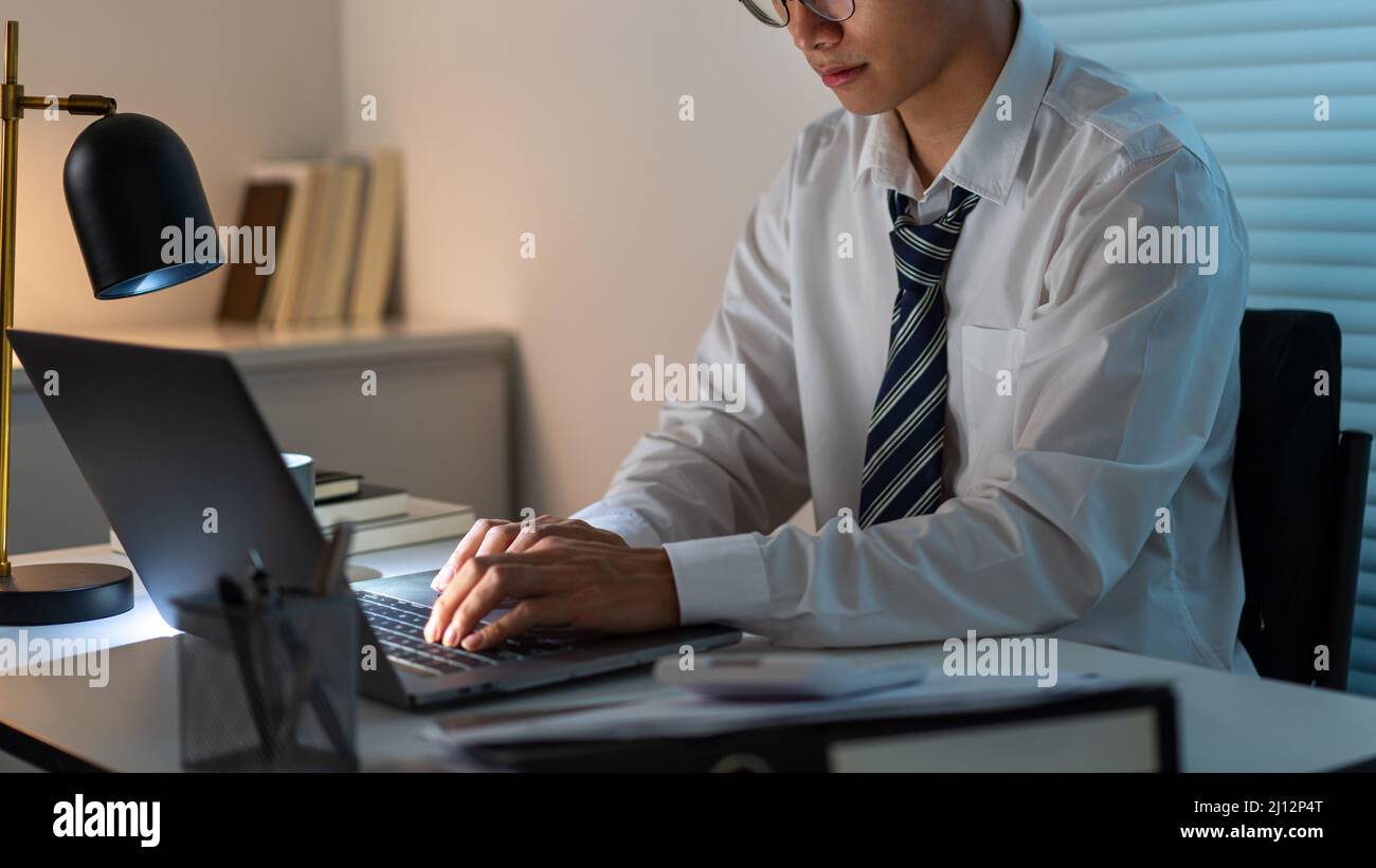 Overwork Concept The man sitting at his desk and focusing on working ...