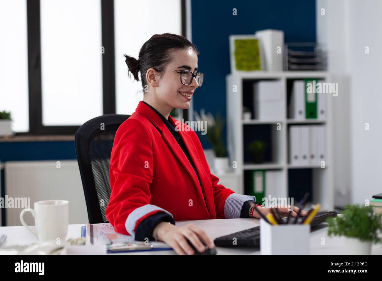 Smiling startup owner with glasses working at desk in office. Happy ...