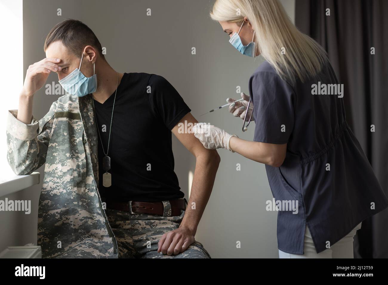 Soldier in uniform receiving vaccine shot against corona virus at the ...