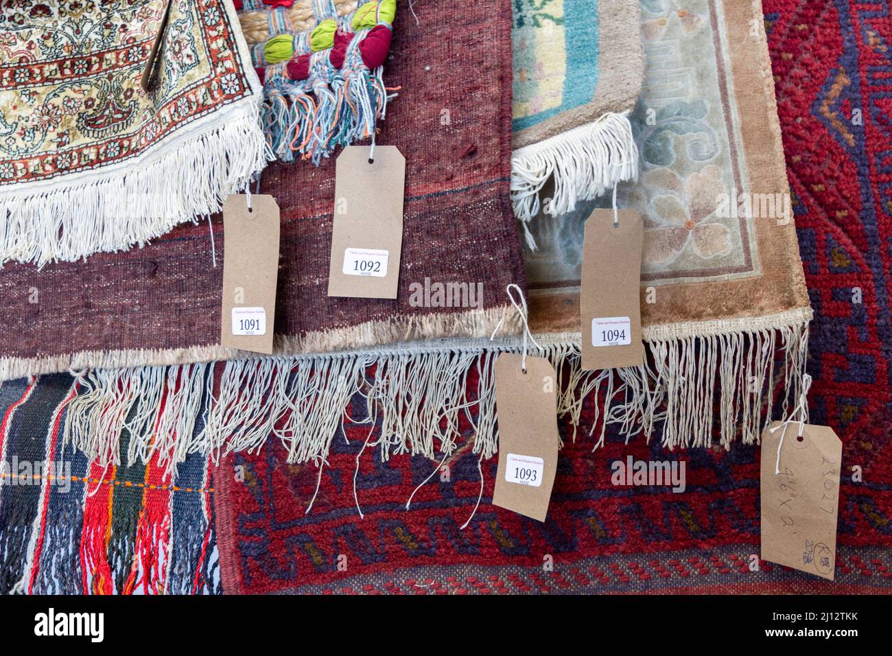 Vintage rugs labelled as auction lots for sale, UK Stock Photo - Alamy