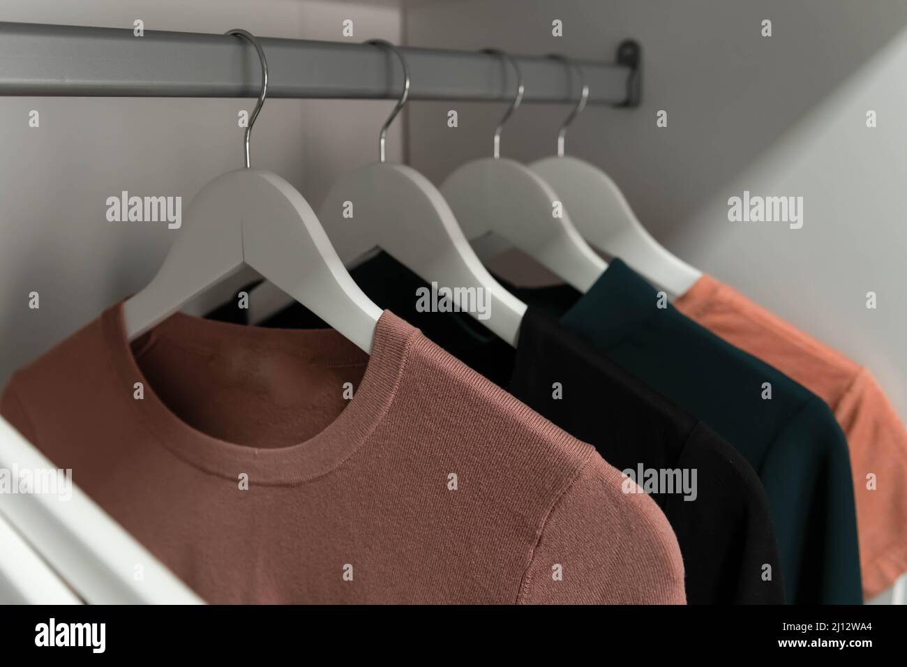 Collection of female clothes hanging on rack. Hangers with clothes ...