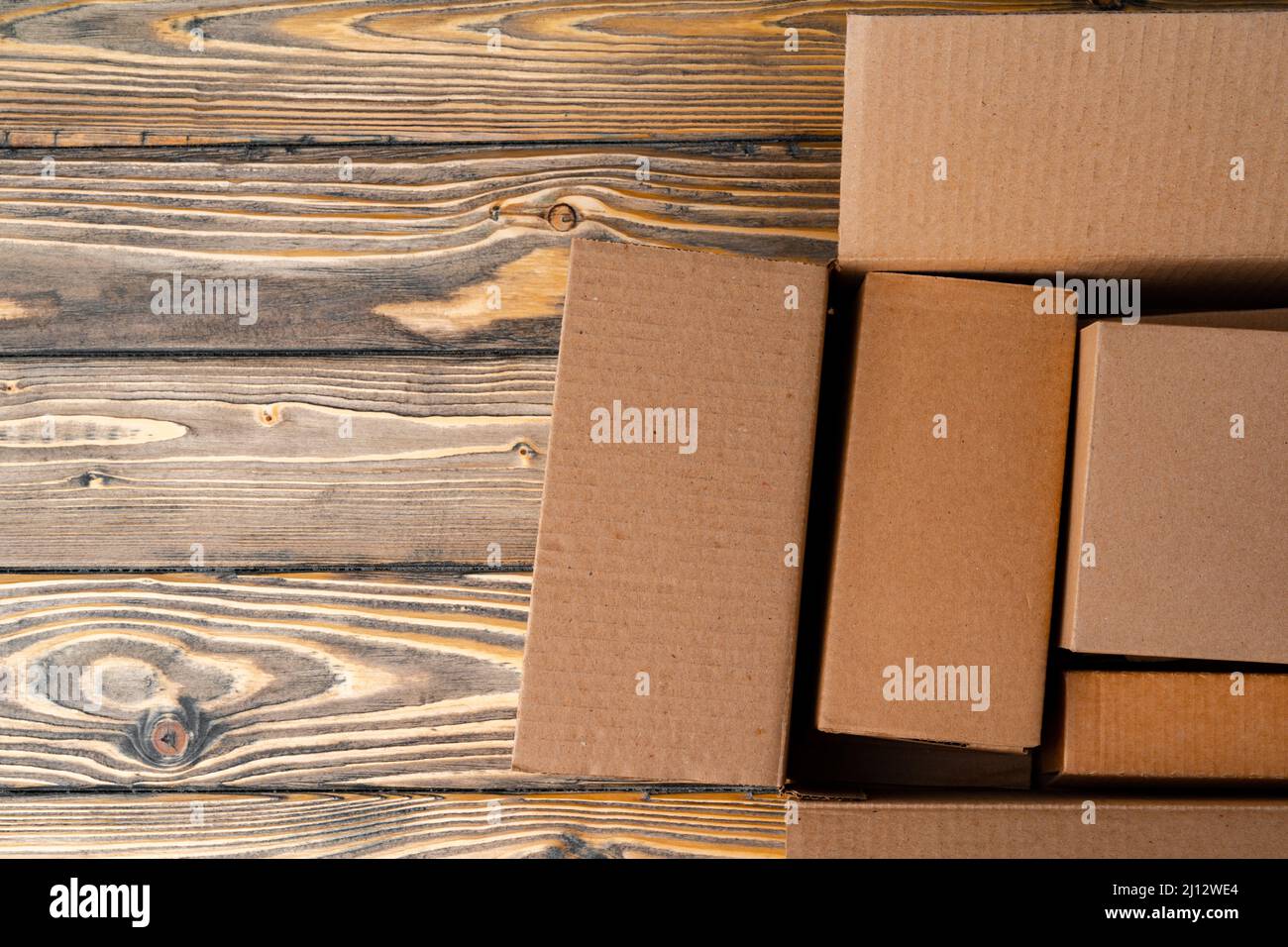 Pile of cardboard boxes on wooden background Stock Photo - Alamy