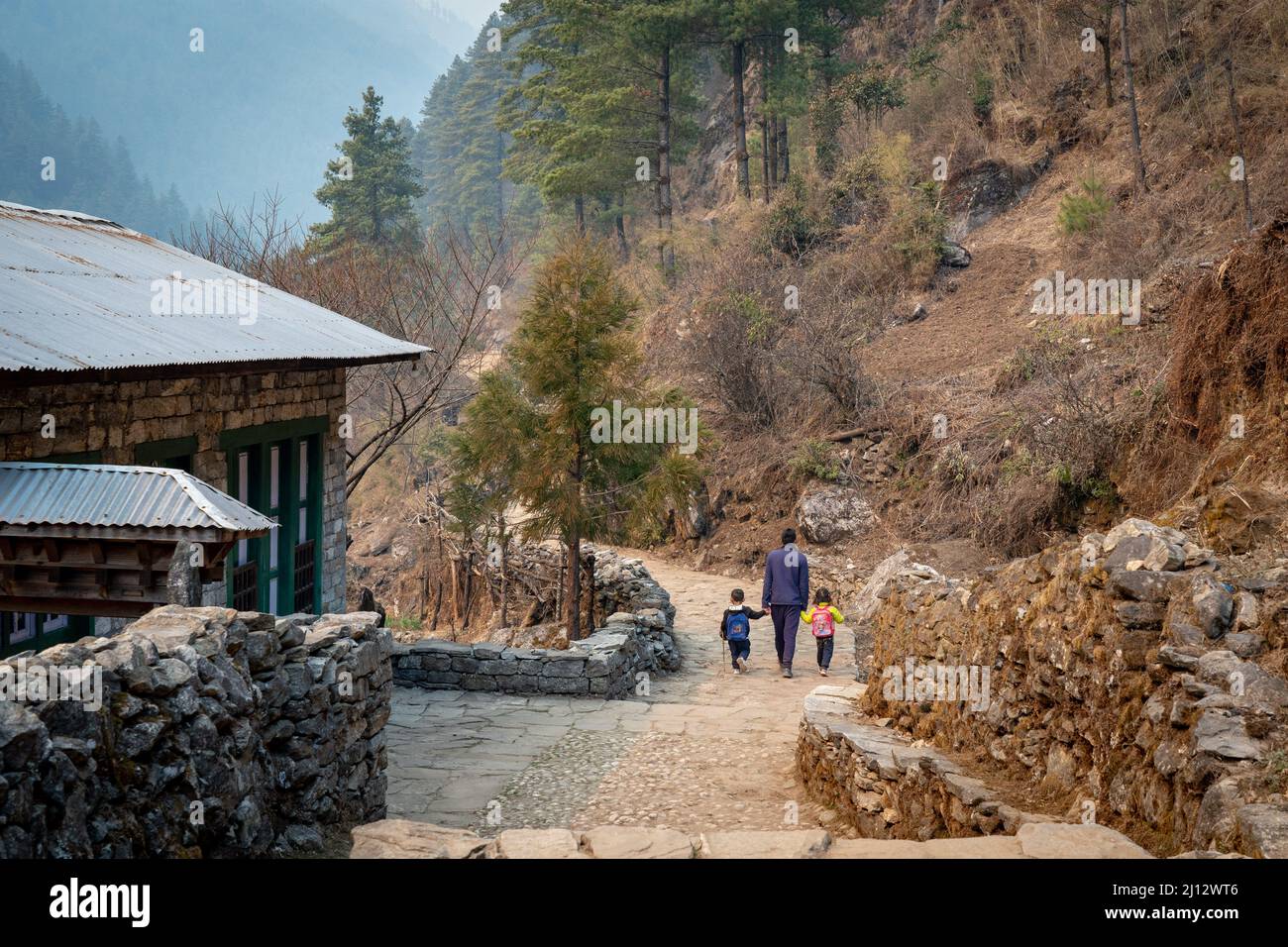 Lukla, Nepal - March 10, 2022: A father with his two children walking ...