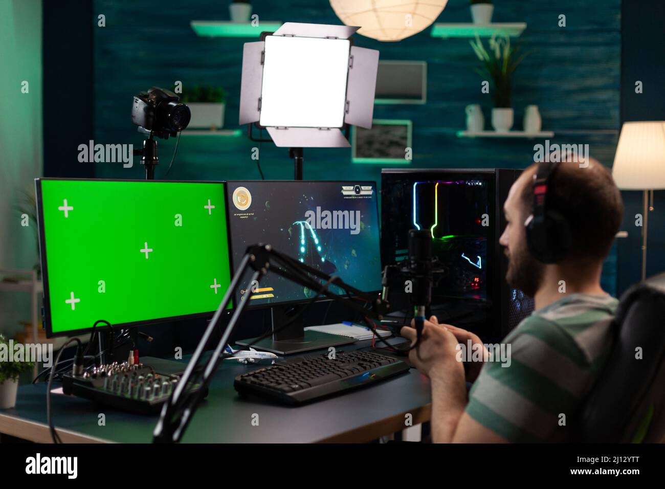 Man streaming video games and using horizontal green screen. Person ...