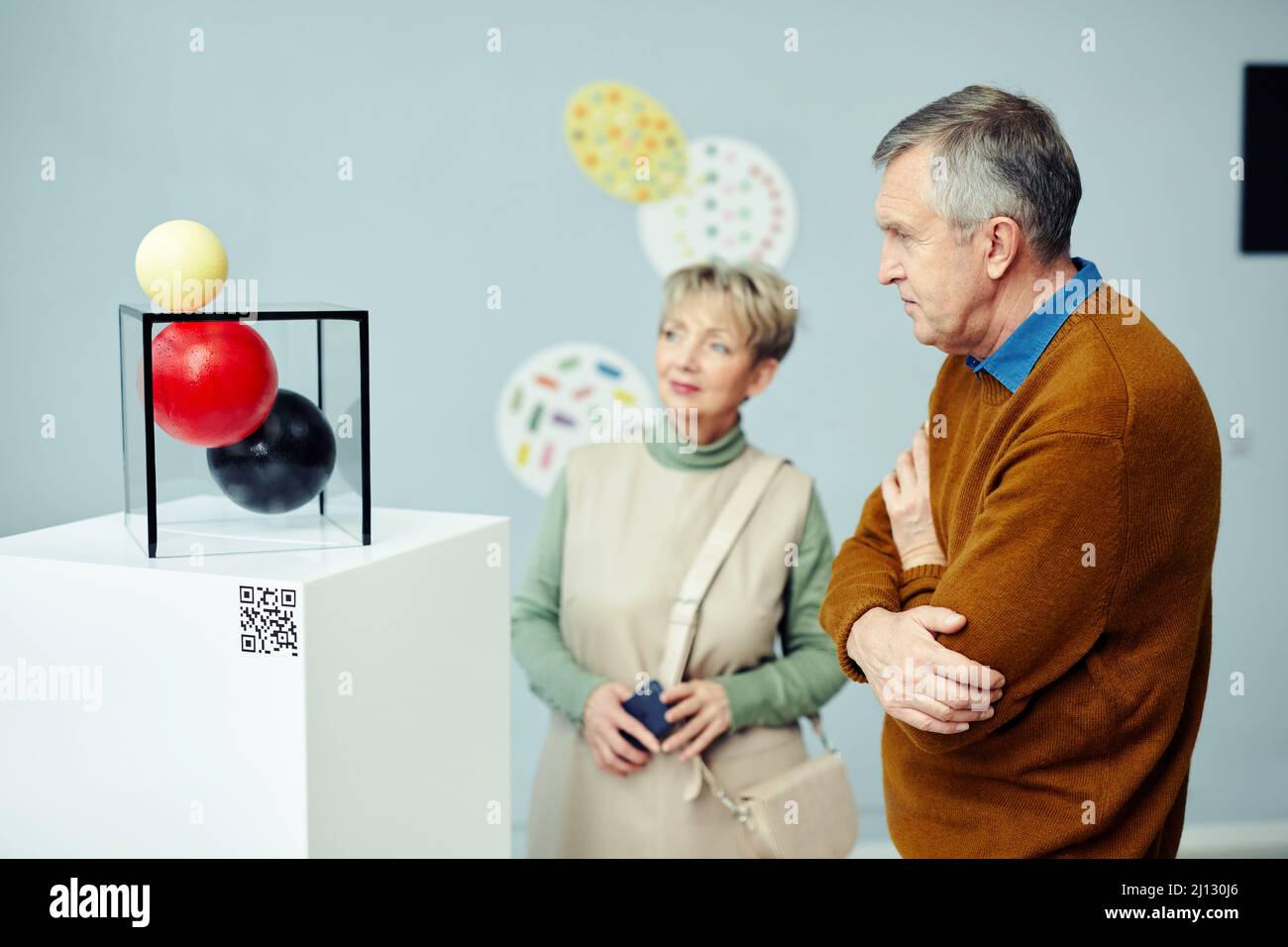 Senior Caucasian man and woman visiting exhibition in museum of modern ...