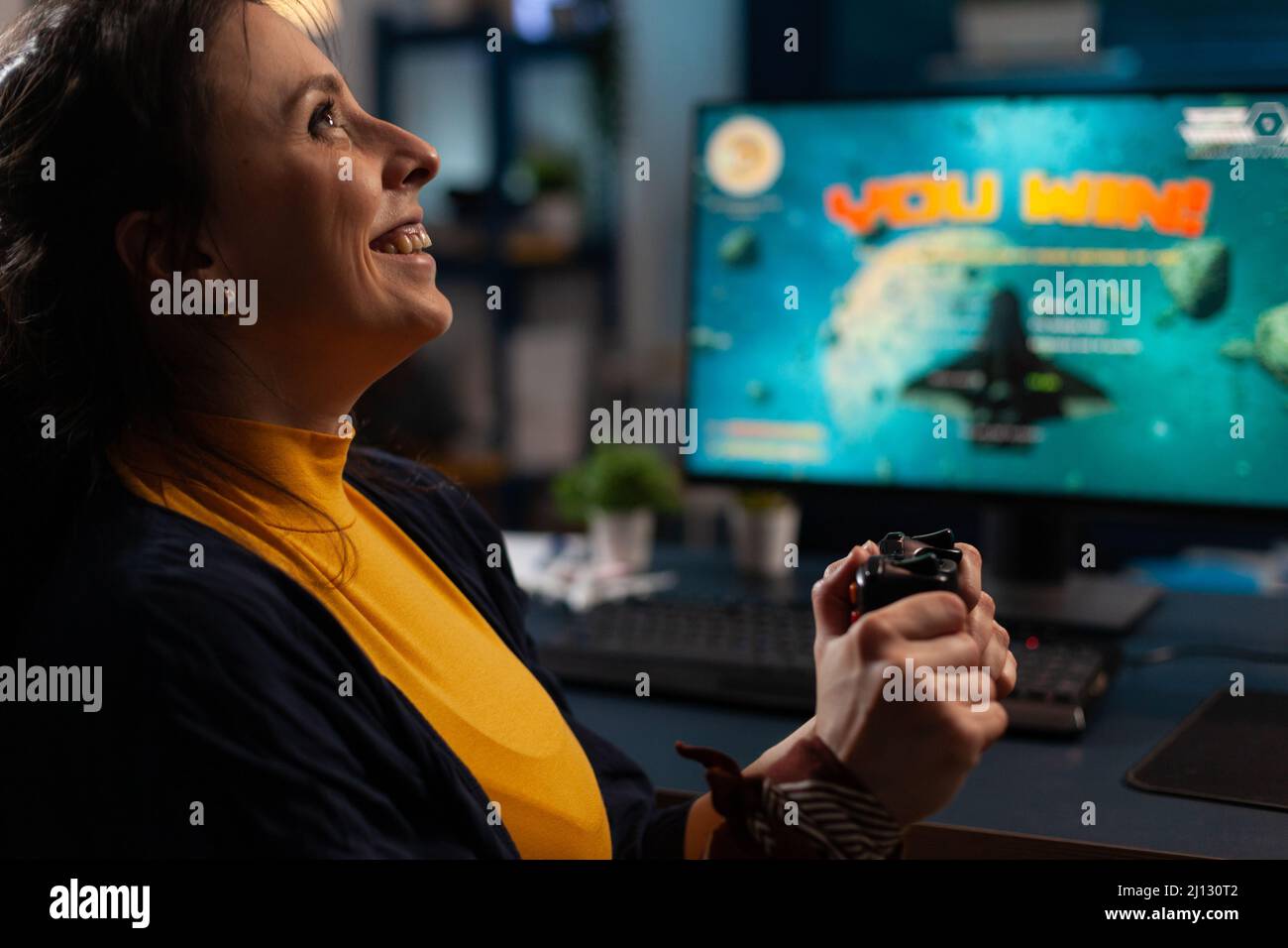 Happy woman using joystick to play video games on computer. Gamer ...