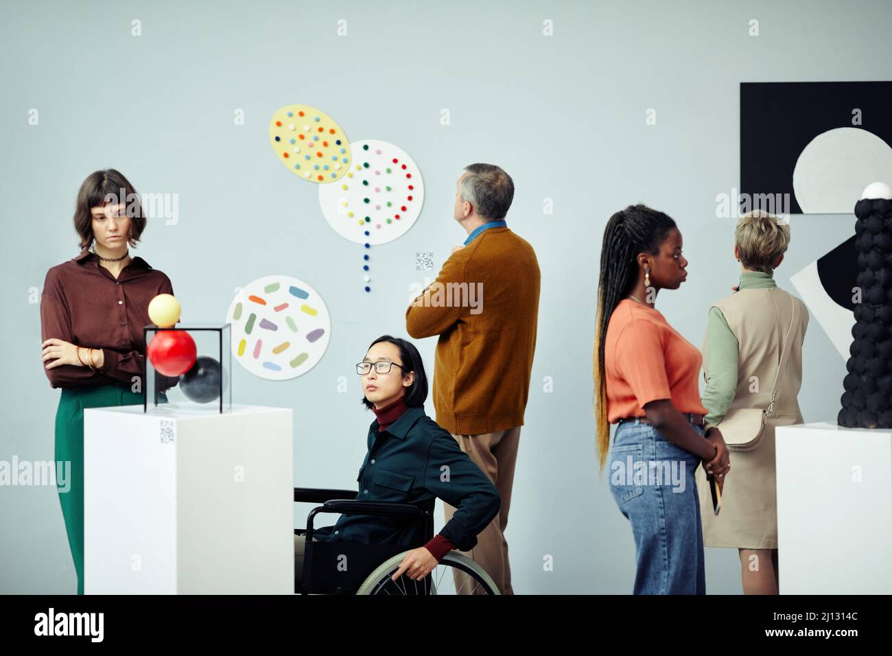 Group of diverse multi-ethnic people looking at various contemporary ...