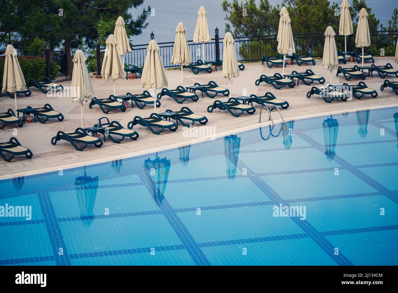 Plastic sun loungers and parasols for sun protection are placed on the ...