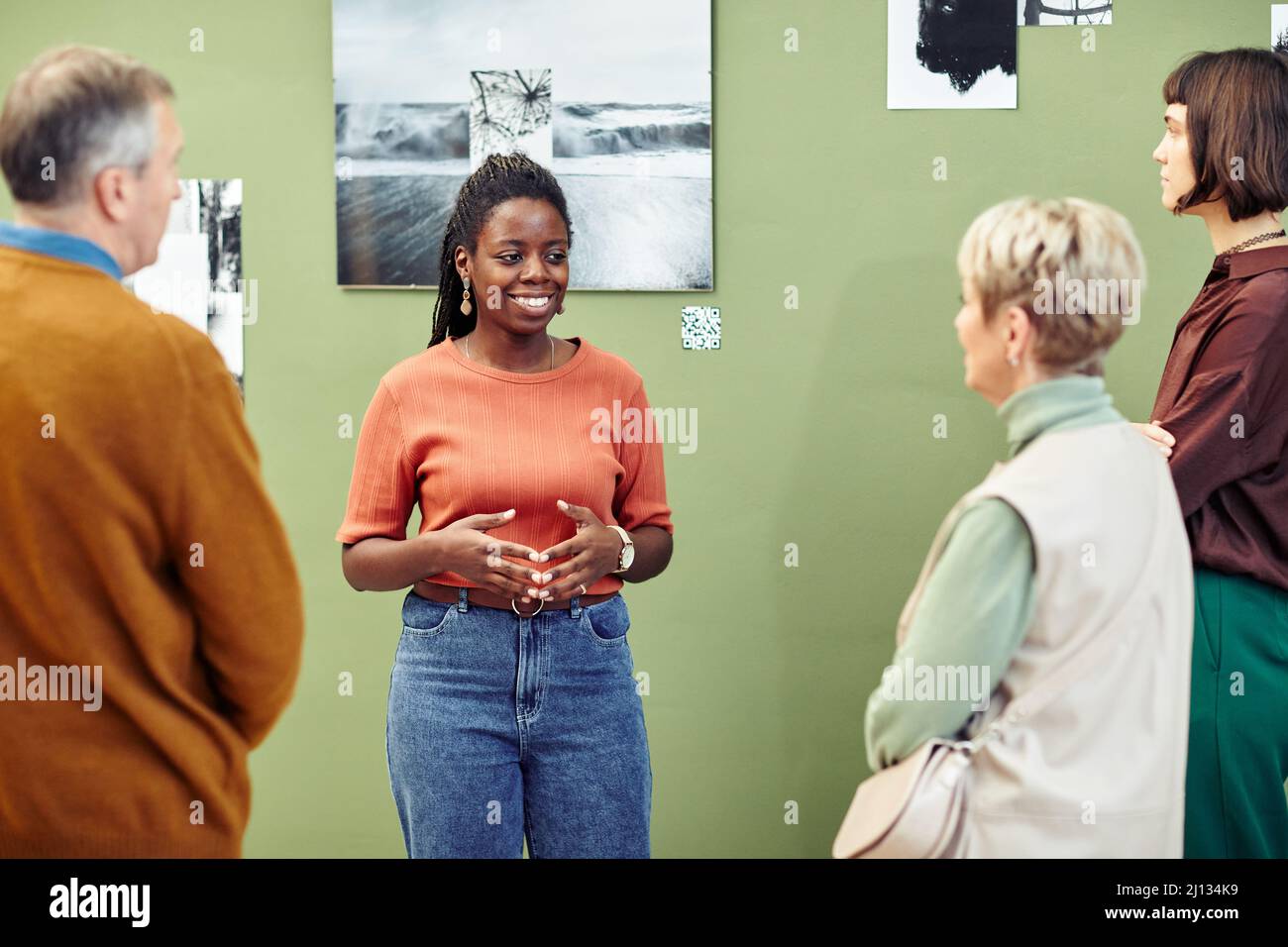 Portrait of cheerful young Black female creator standing in front of ...