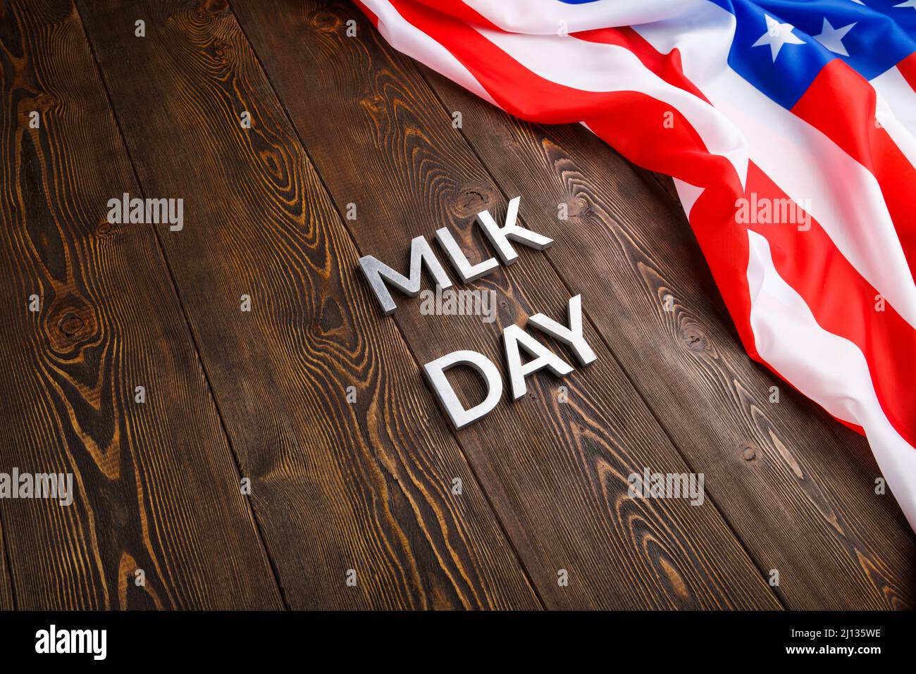 the word MLK day laid with silver metal letters on wooden surface with ...