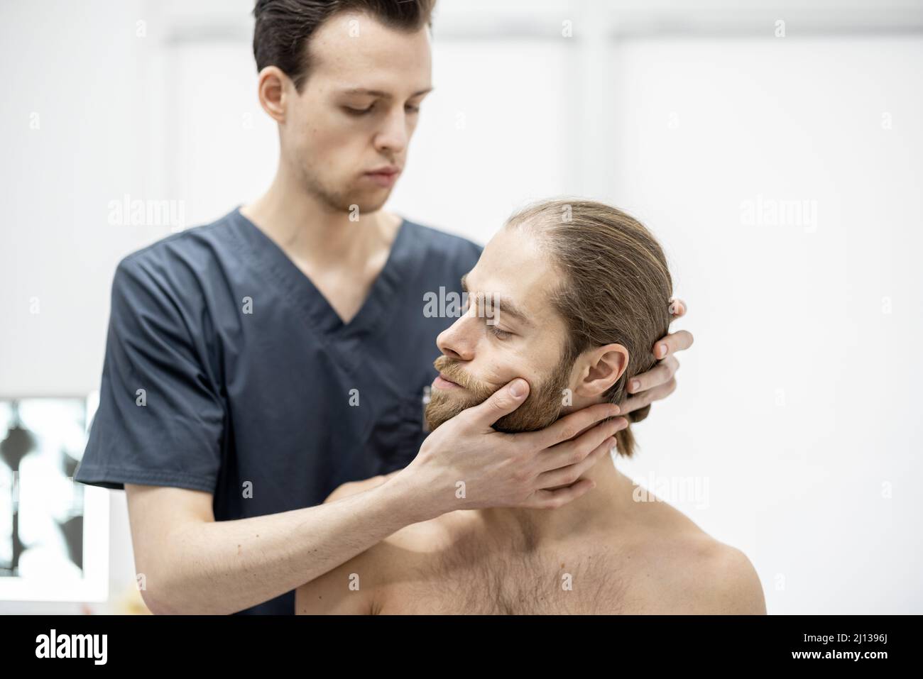 Physical therapist does manual therapy to a young athletic guy at ...