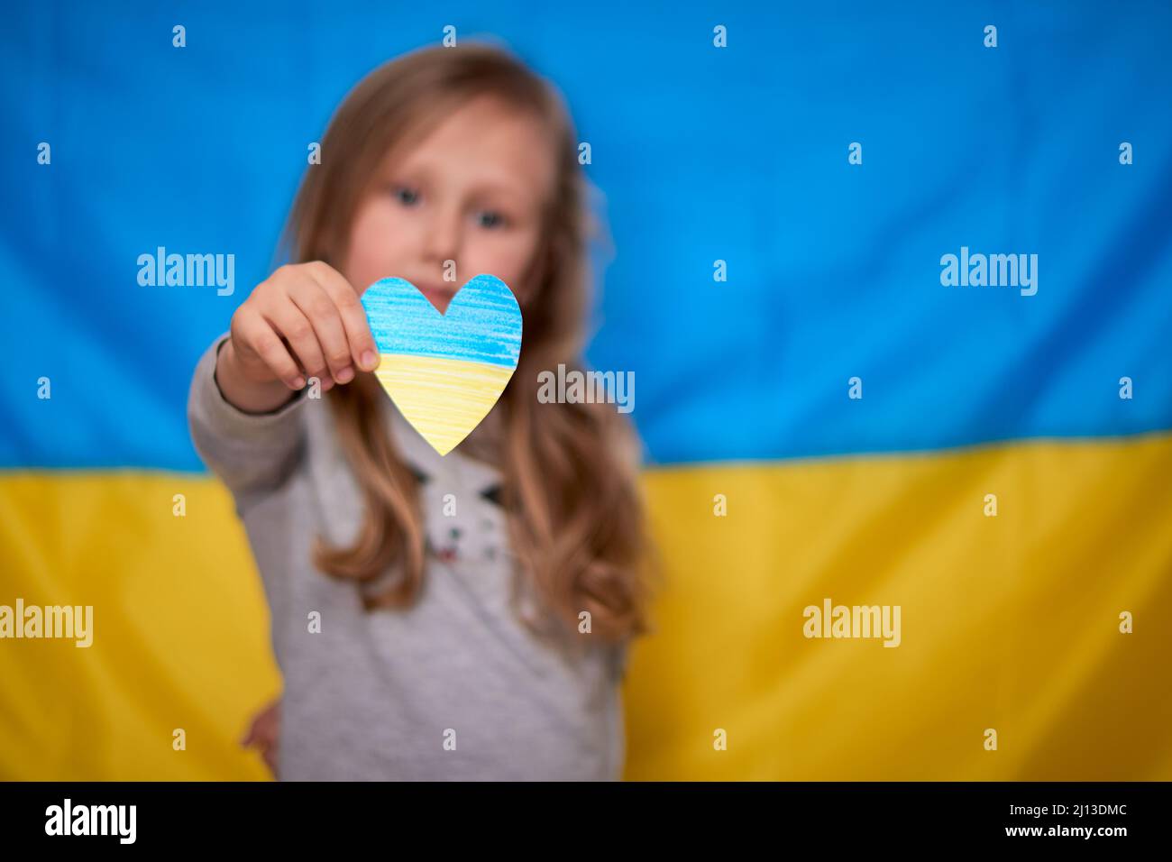 Girl hands holding yellow-blue paper hearts on Ukrainian flag ...
