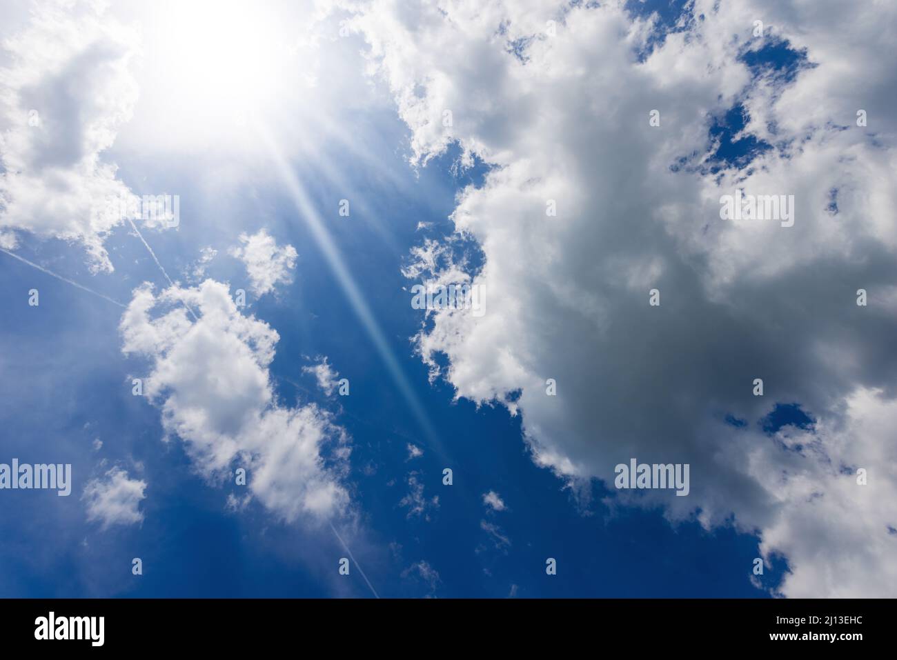 Beautiful blue sky with white cumulus clouds and sun rays (sunbeams ...