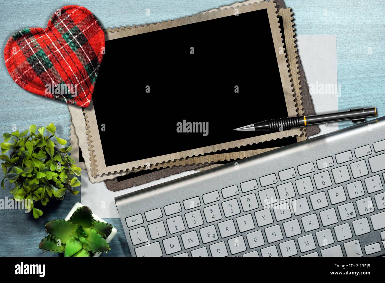 Close-up of a fabric heart shape on a stack of vintage and blank photo ...