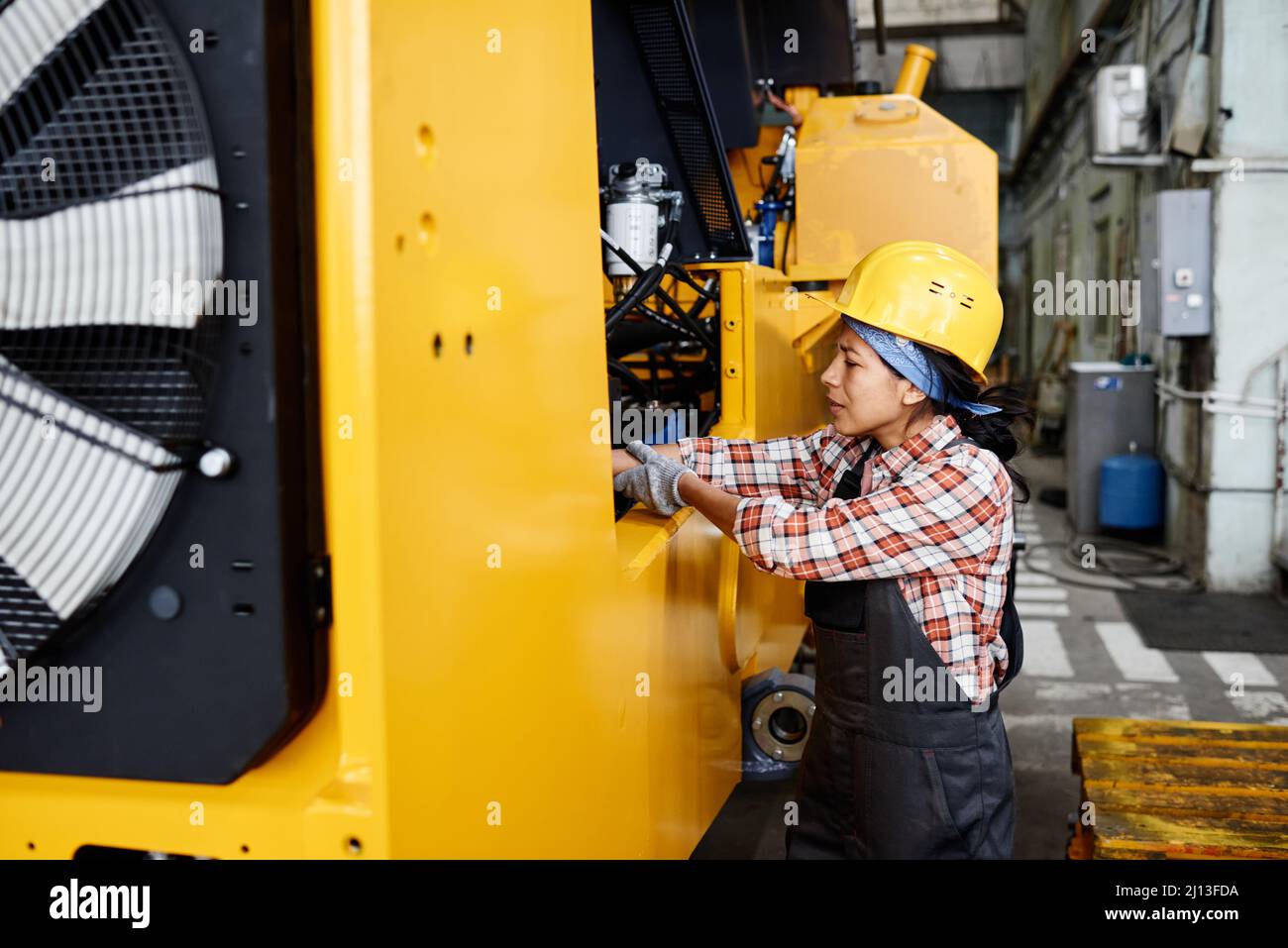 Young female engineer with damaged hand or arm standing by industrial ...