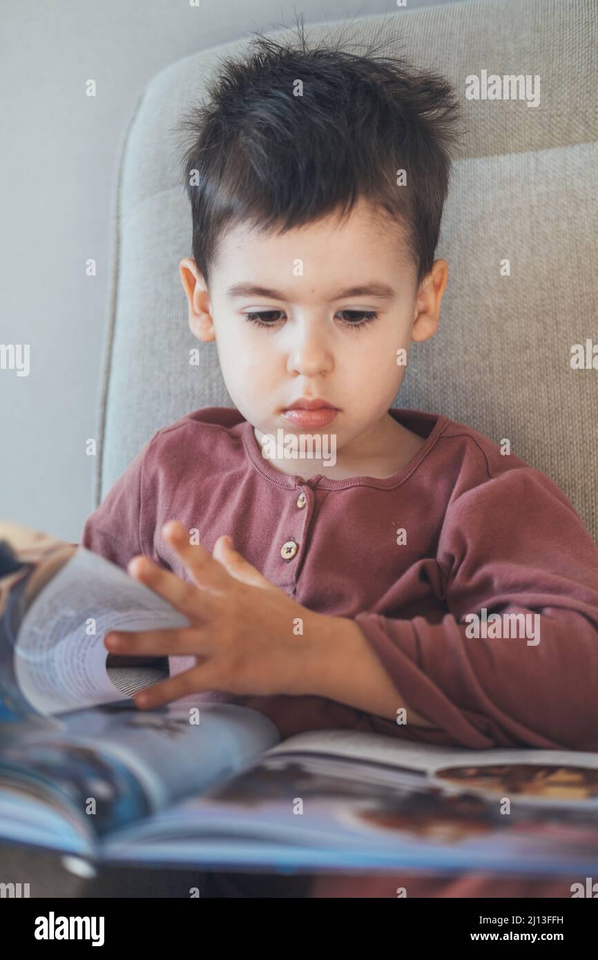 Boy sitting on a sofa reading hi-res stock photography and images - Alamy
