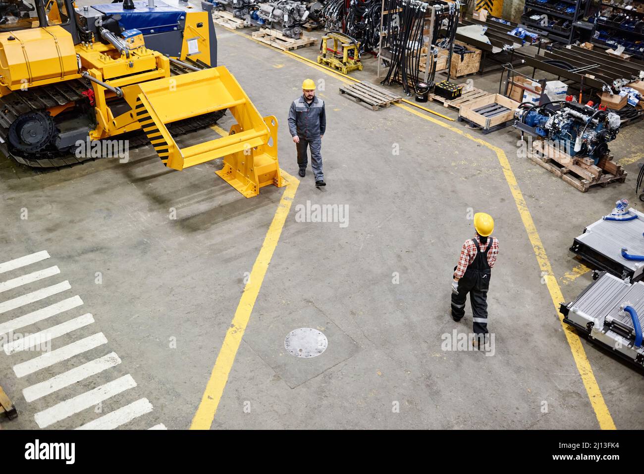 Two workers of industrial plant moving towards one another while ...