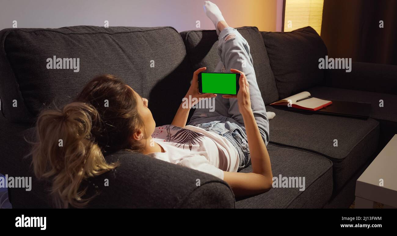 Woman staying home and waching horizontal phone Green Mock-up Screen ...