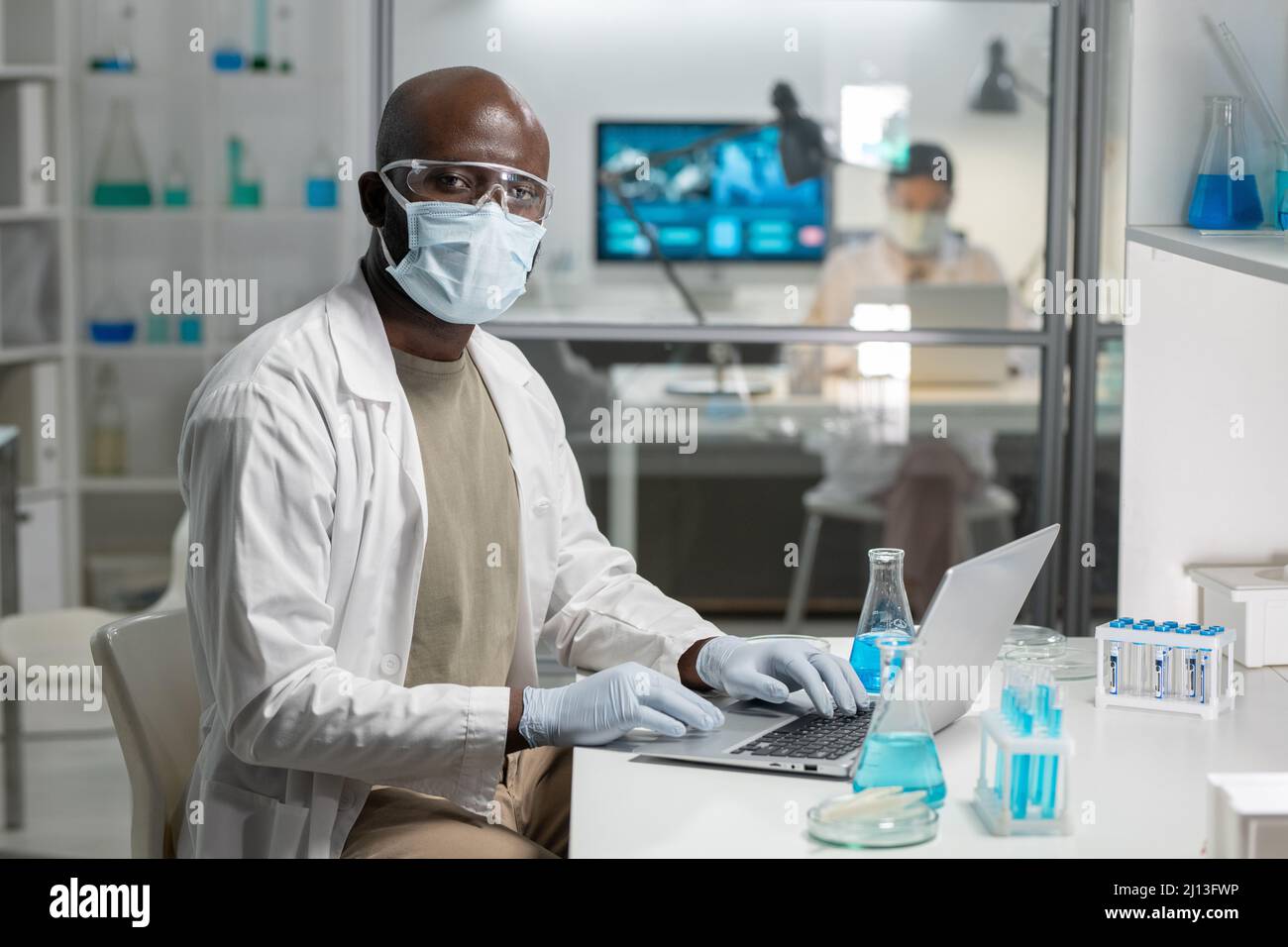 Scientist in protective gloves typing hi-res stock photography and ...