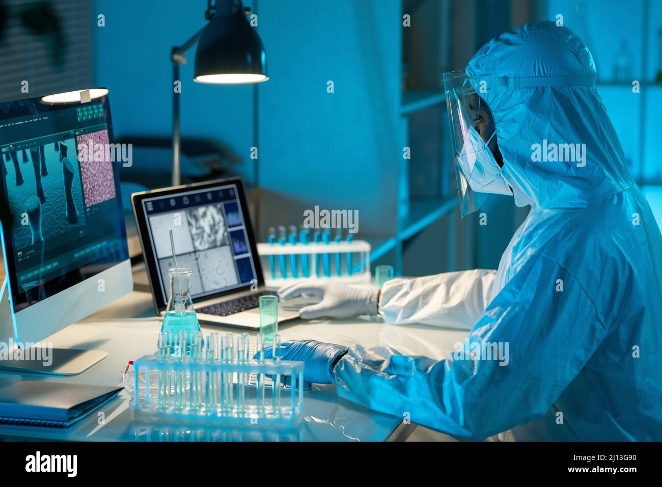 Side view of contemporary African American virologist in protective ...