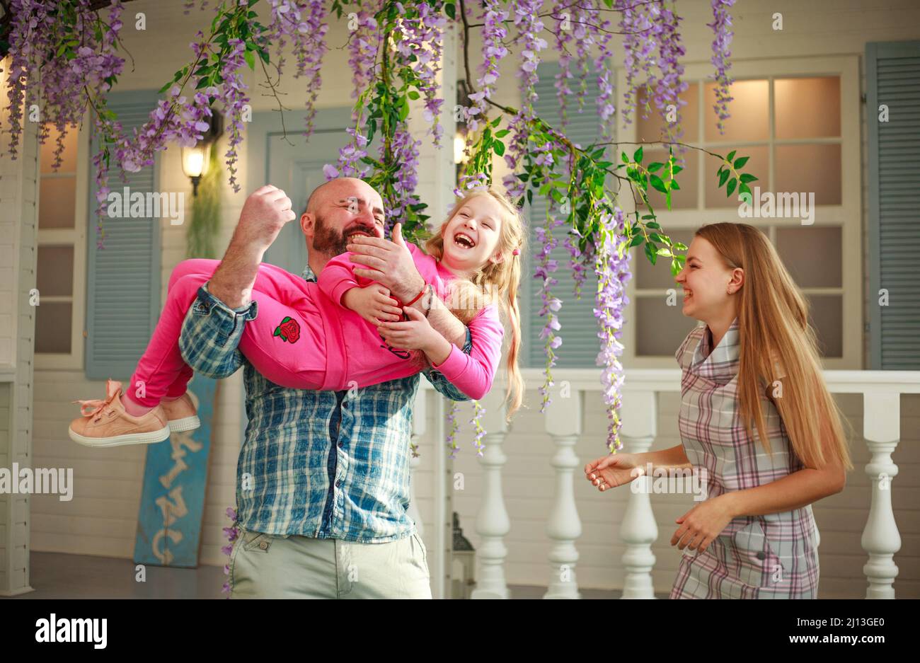 Happy parents with daughter have fun playing holding child on his hands ...