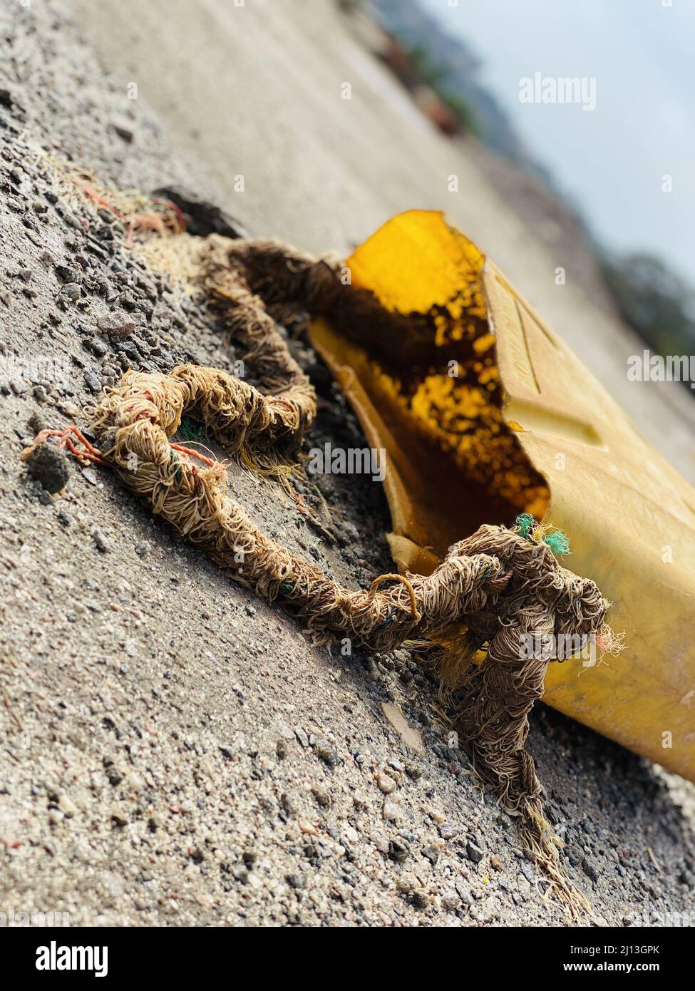Closeup shot of an old wet rope out from old plastic container on ...