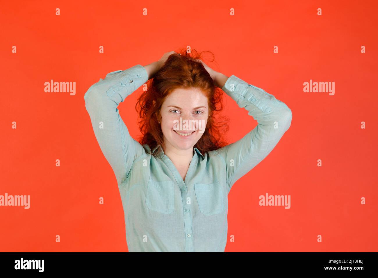 Business portrait of beautiful young woman with red curly hair and blue ...