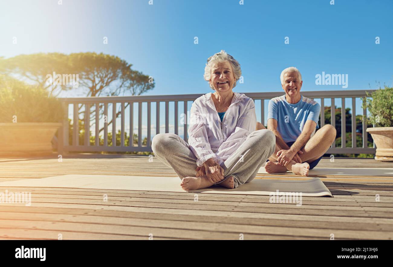 Keeping a healthy mind and body. Shot of a senior couple doing yoga ...