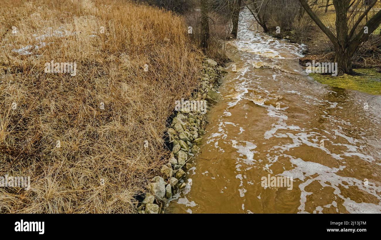 The river is overflowing after a night of rain melting the snow Stock ...