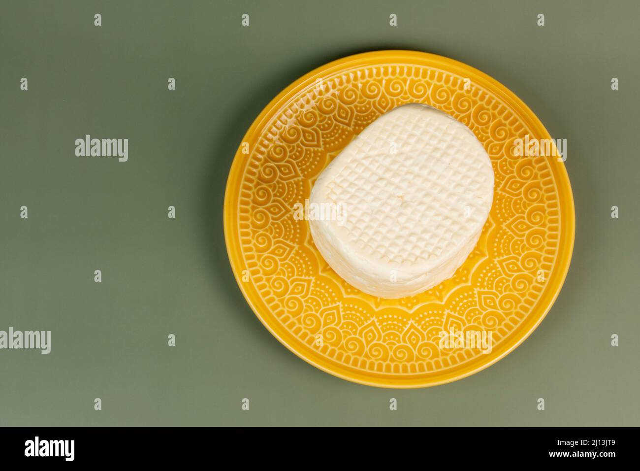 typical Brazilian Minas cheese from Minas Gerais on a yellow plate ...