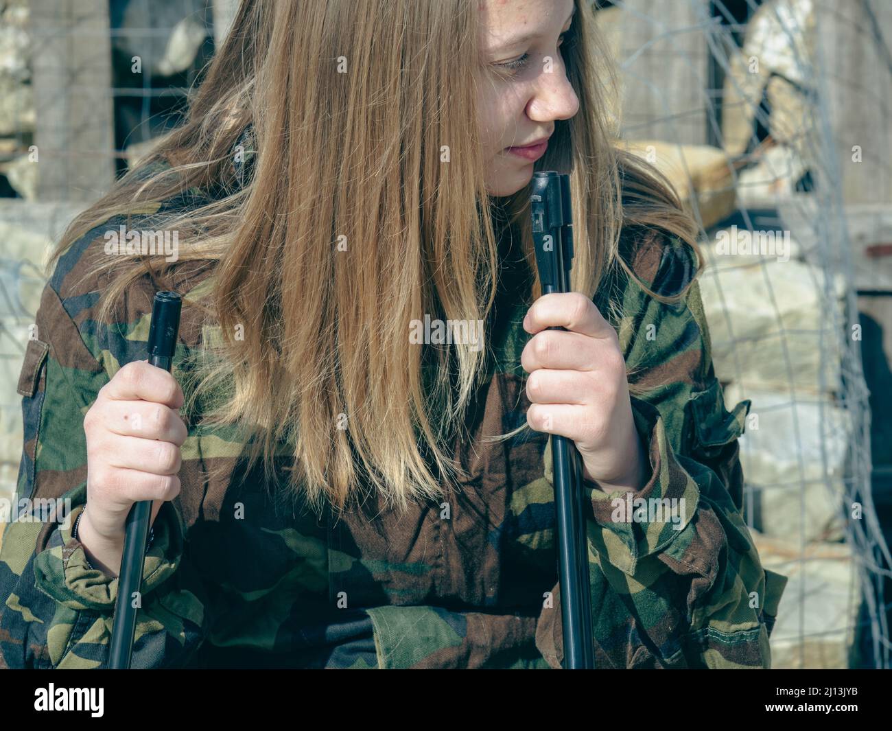 caucasian blond teen aged soldier girl on a checkpoint holding a rifle ...