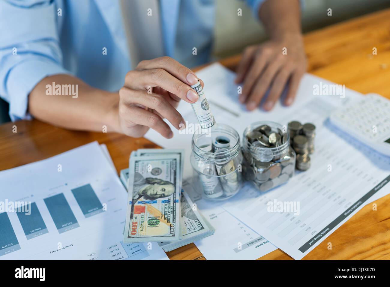 Saving concept the male young adult rolling his cash and putting it ...