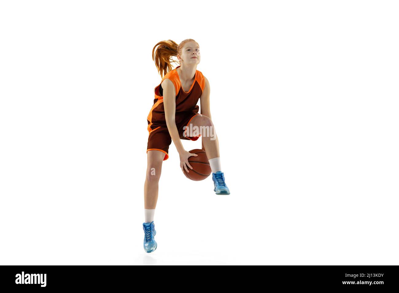 Portrait of young active girl, basketball player in motion, dribblig ...
