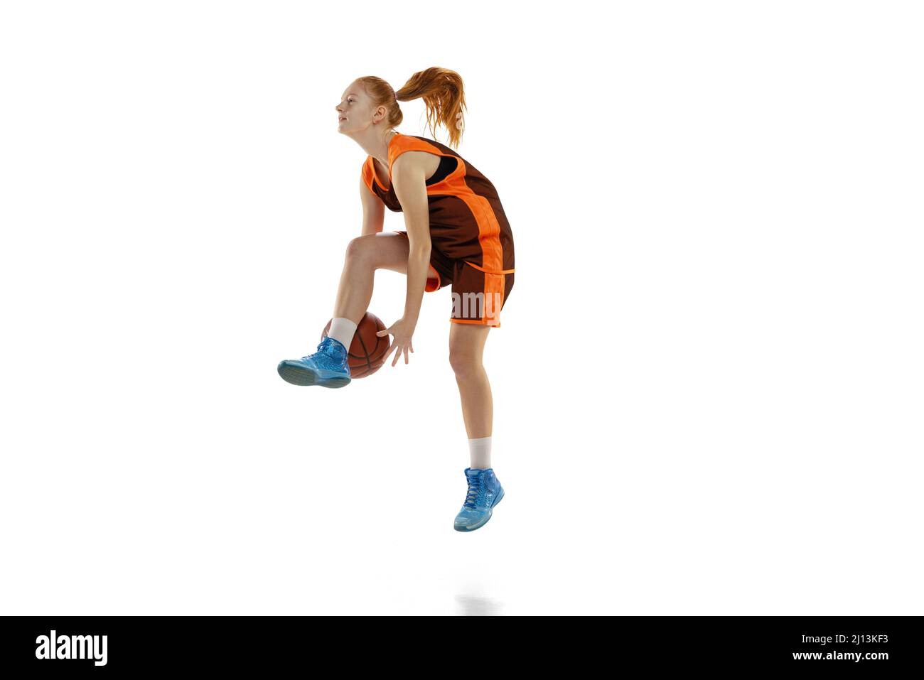Portrait of young active girl, basketball player training, dribblig ...