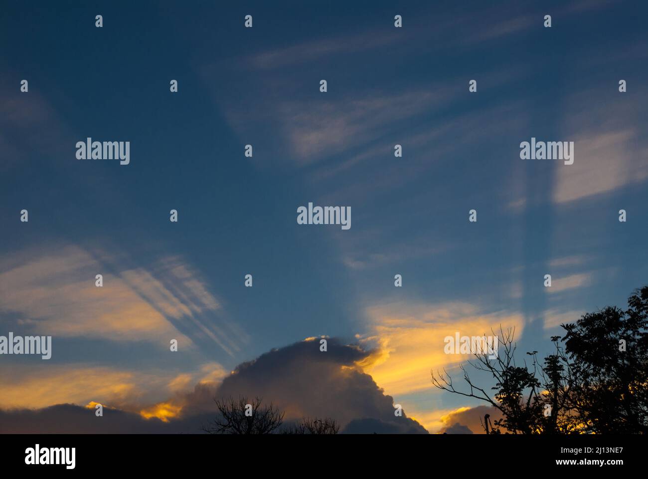Sunset with clouds and shadows with partially clear sky, shadows cast ...