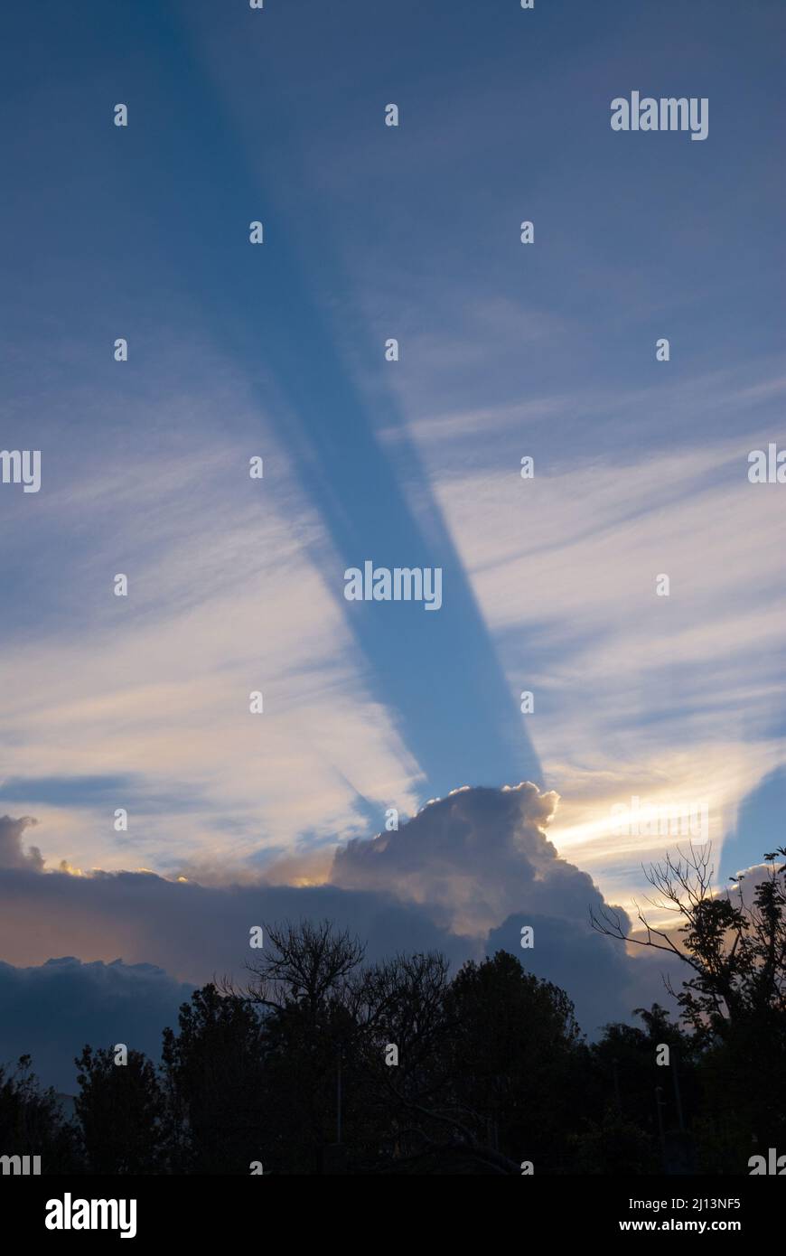 Sunset with clouds and shadows with partially clear sky, shadows cast ...