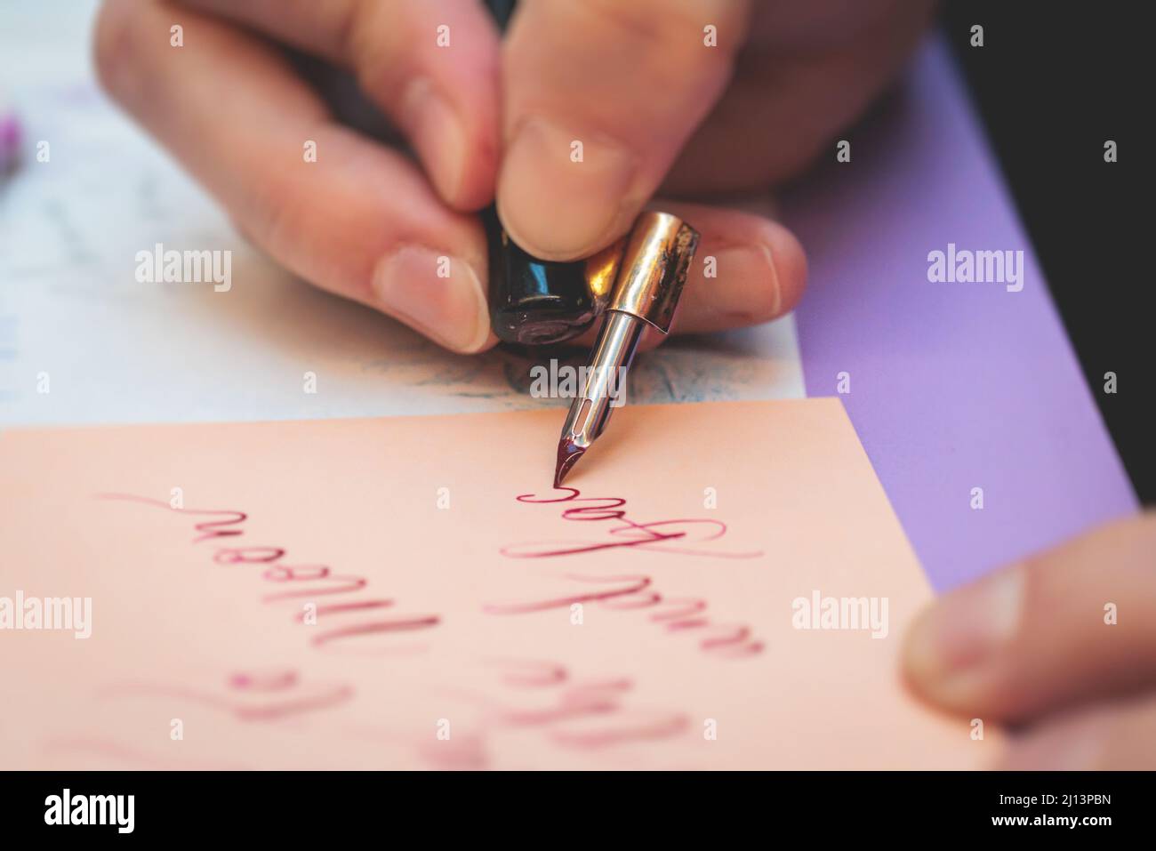 Process of calligraphy handwriting with an ink fountain pen feather ...