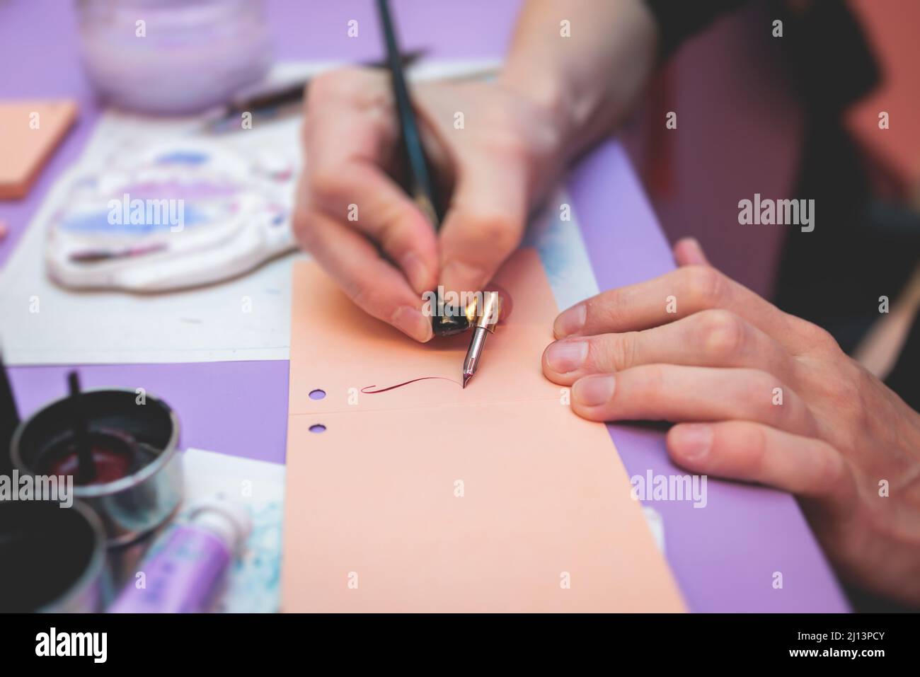 Process of calligraphy handwriting with an ink fountain pen feather ...