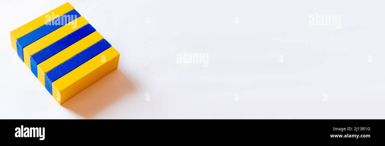 top view of tetragonal blue and yellow blocks on white background ...