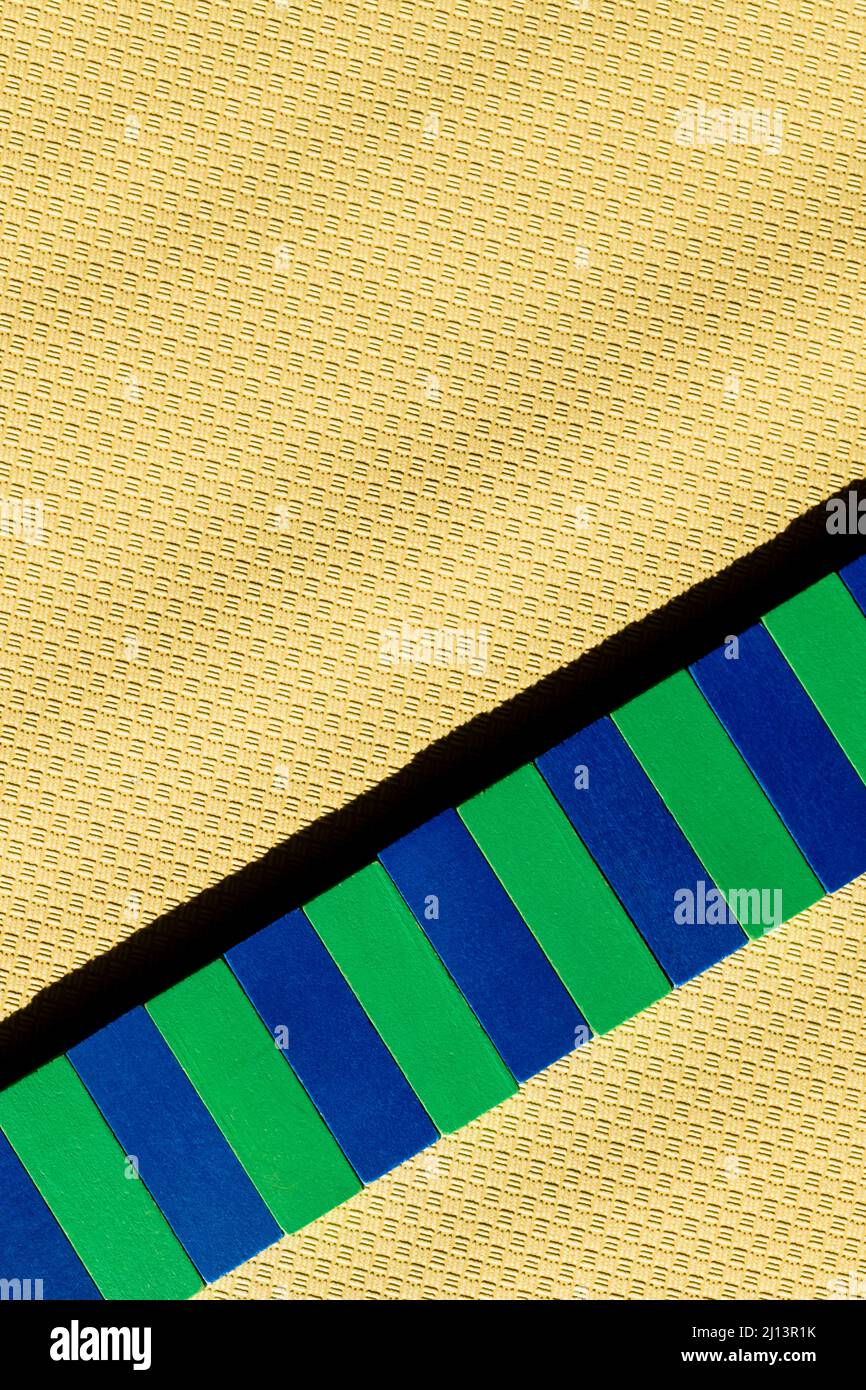 top view of blue and green blocks line on beige textured surface with ...