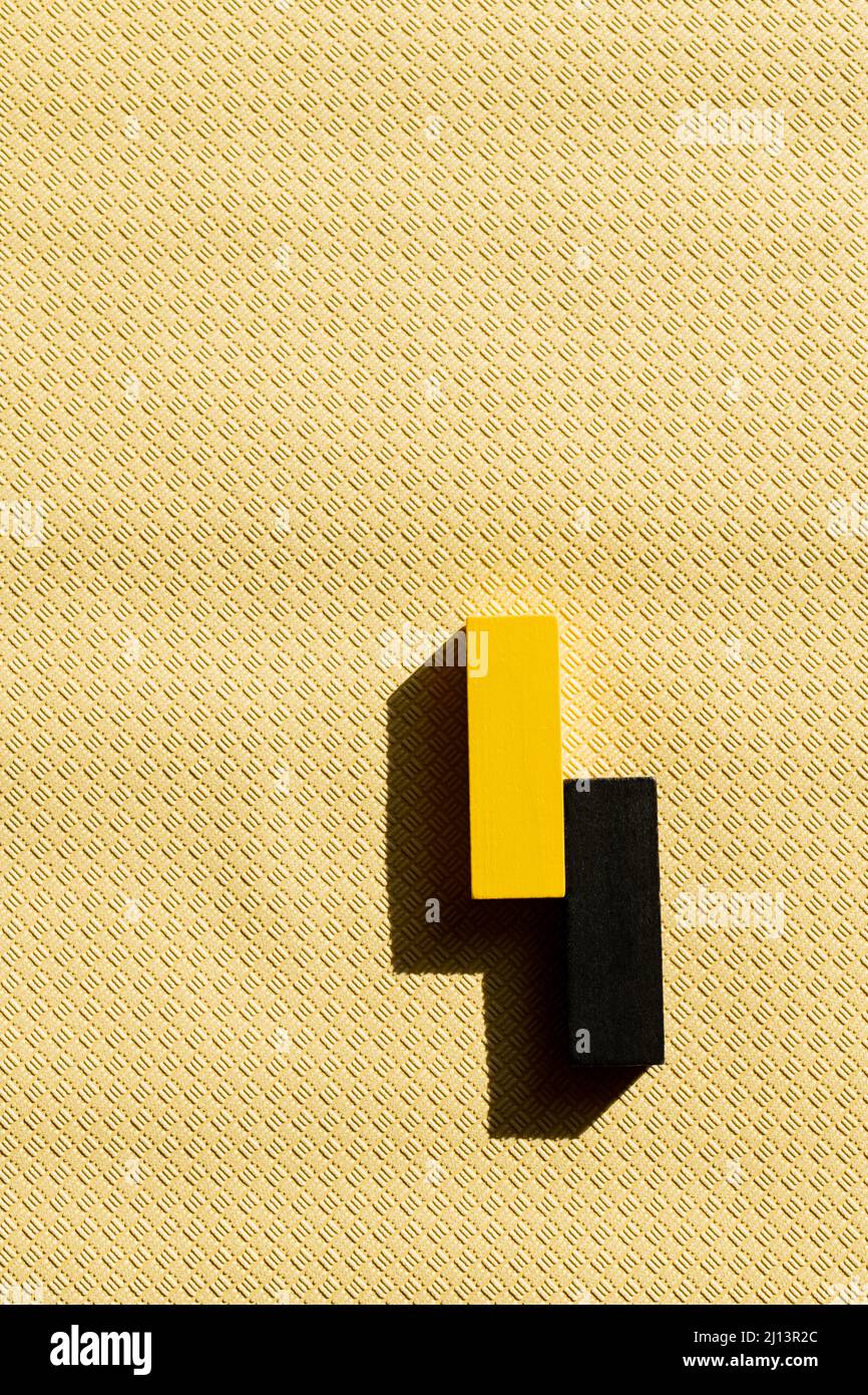top view of black and yellow blocks on beige textured background with ...
