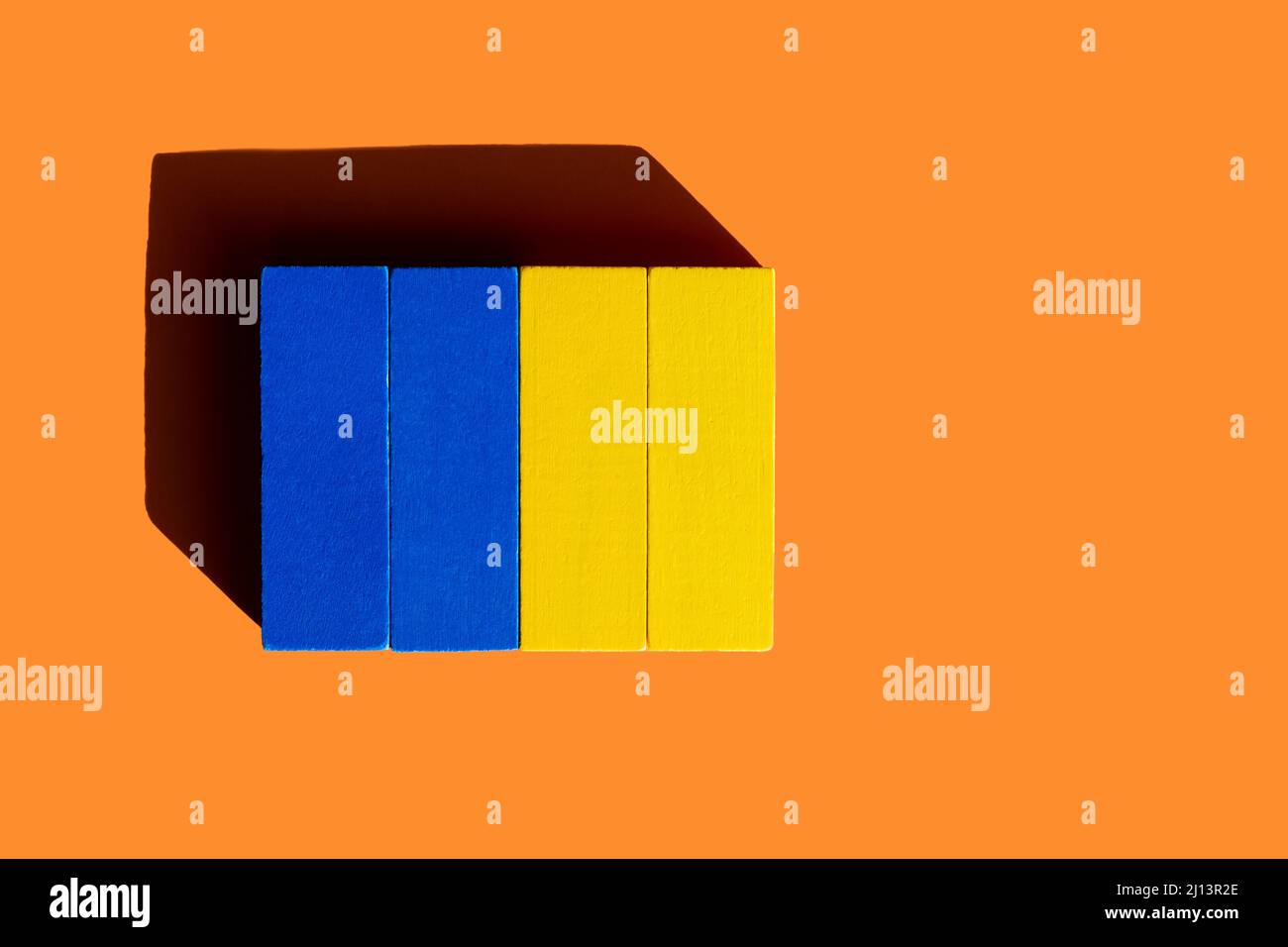 top view of colorful blue and yellow blocks on orange background ...
