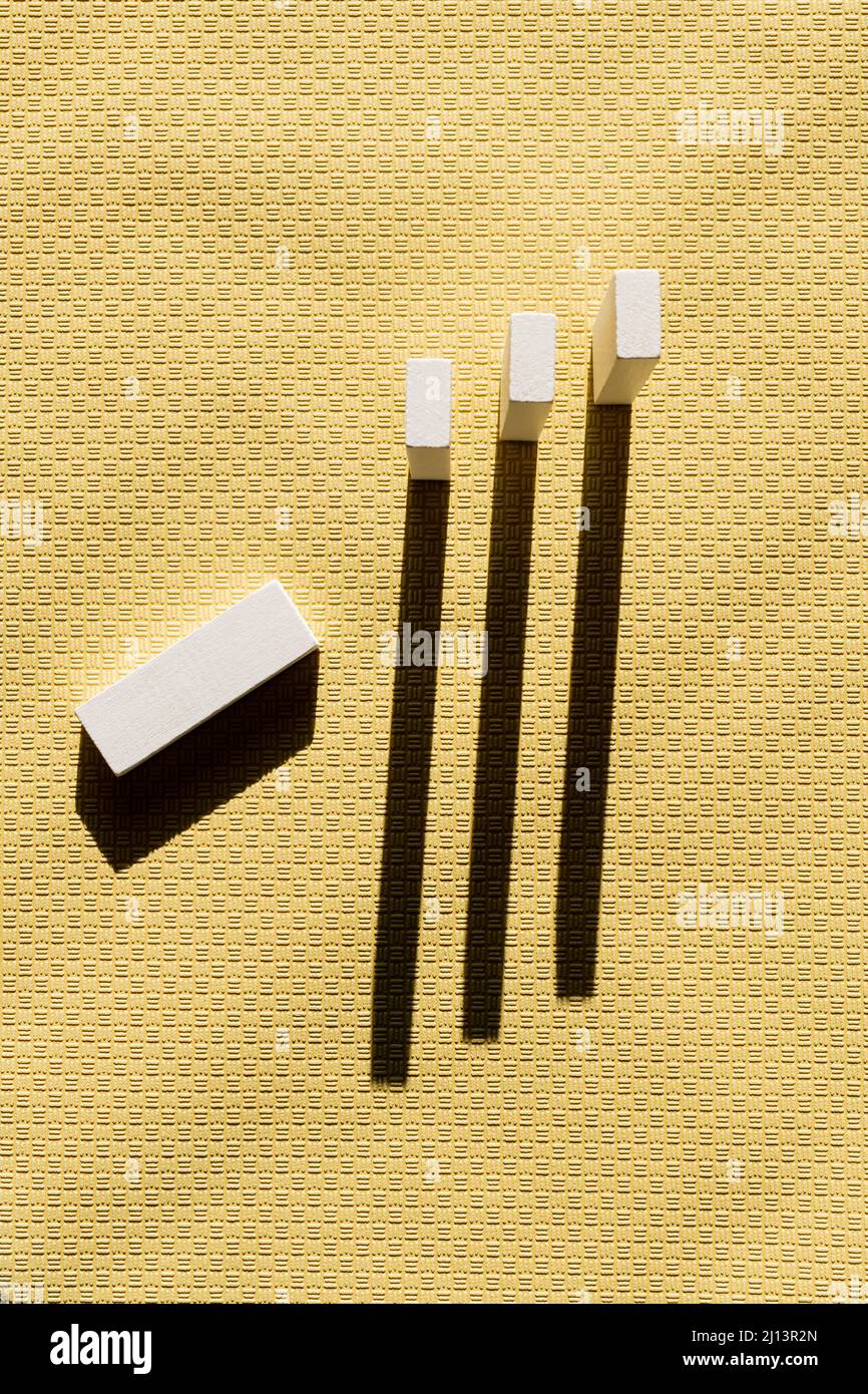 top view of white blocks on beige textured background with shadows ...
