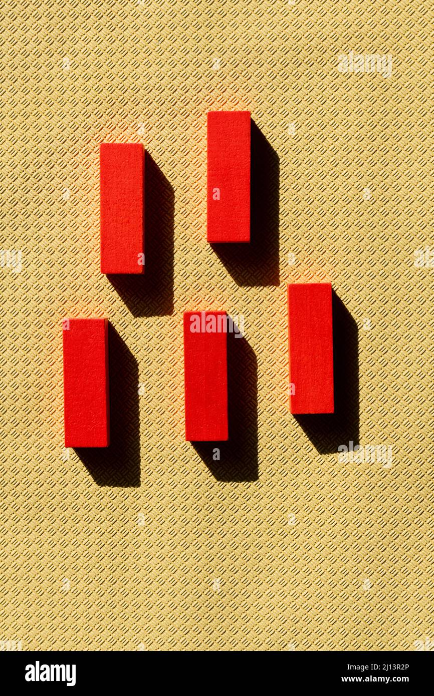 top view of bright red blocks on beige textured background with shadows ...