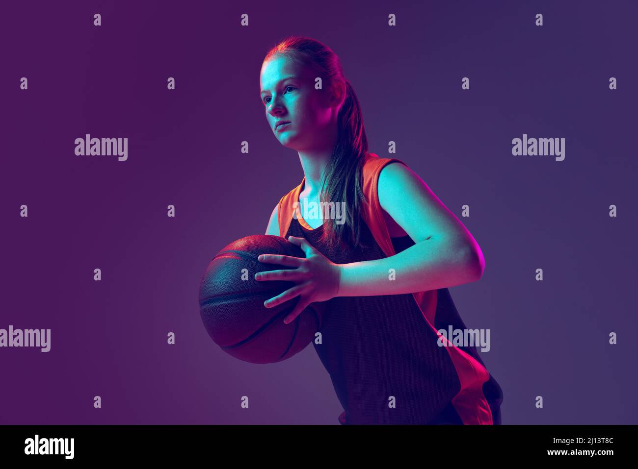 Portrait of young girl, basketball player in brown uniform training ...
