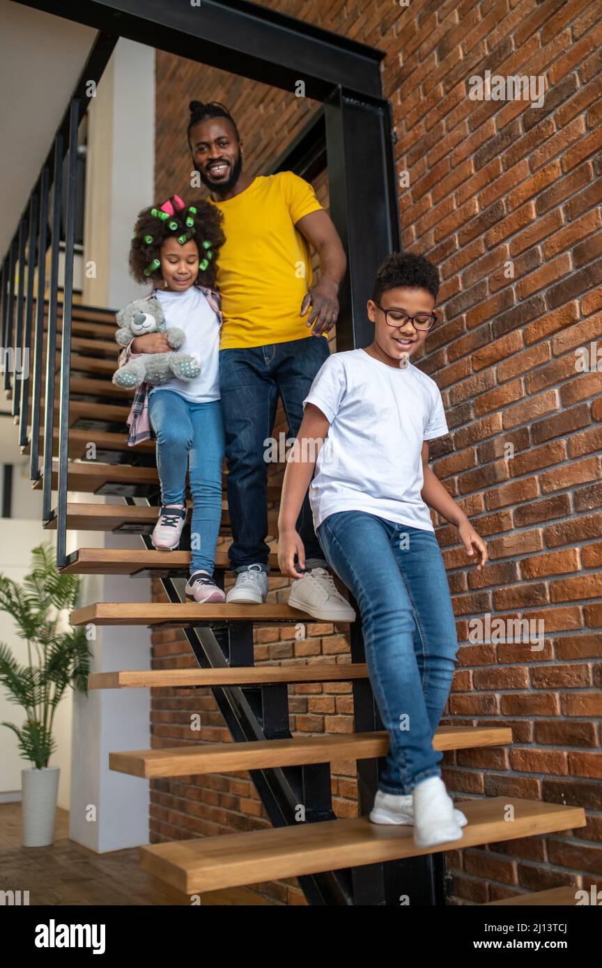 Bottom view of man with children descending stairs Stock Photo - Alamy