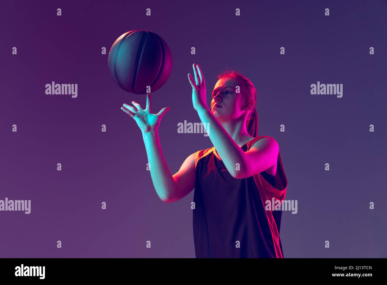 Portrait of young girl, basketball player training, spinning ball on ...