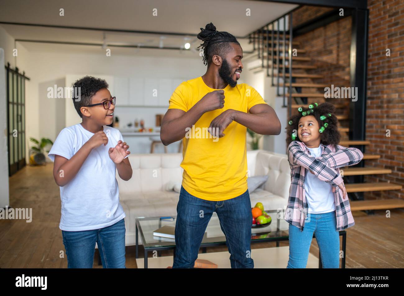 Man and children moving their hands in same way Stock Photo - Alamy